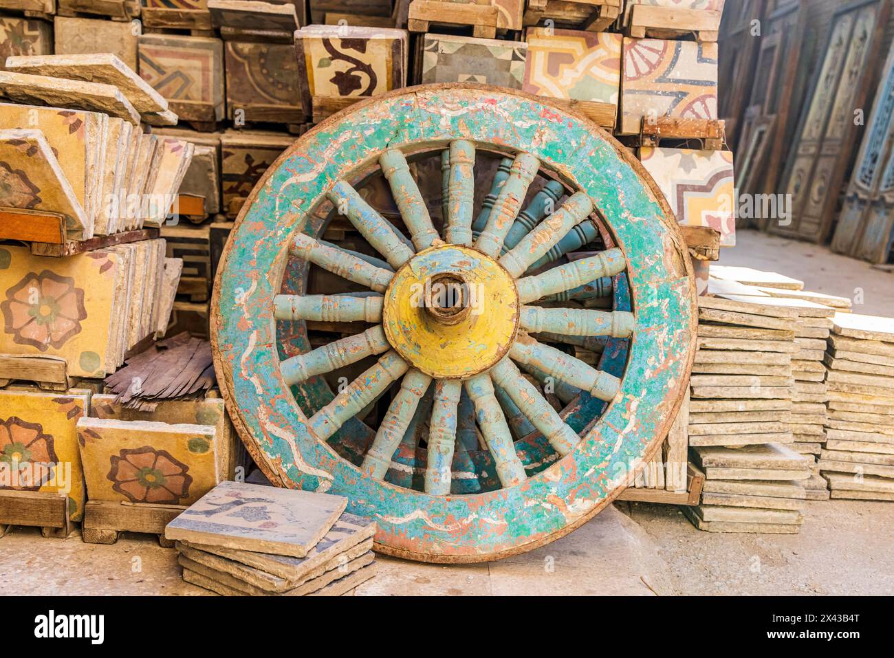 Old Cairo, Cairo, Egypt. Wooden cart wheel and floor tiles in an alley ...