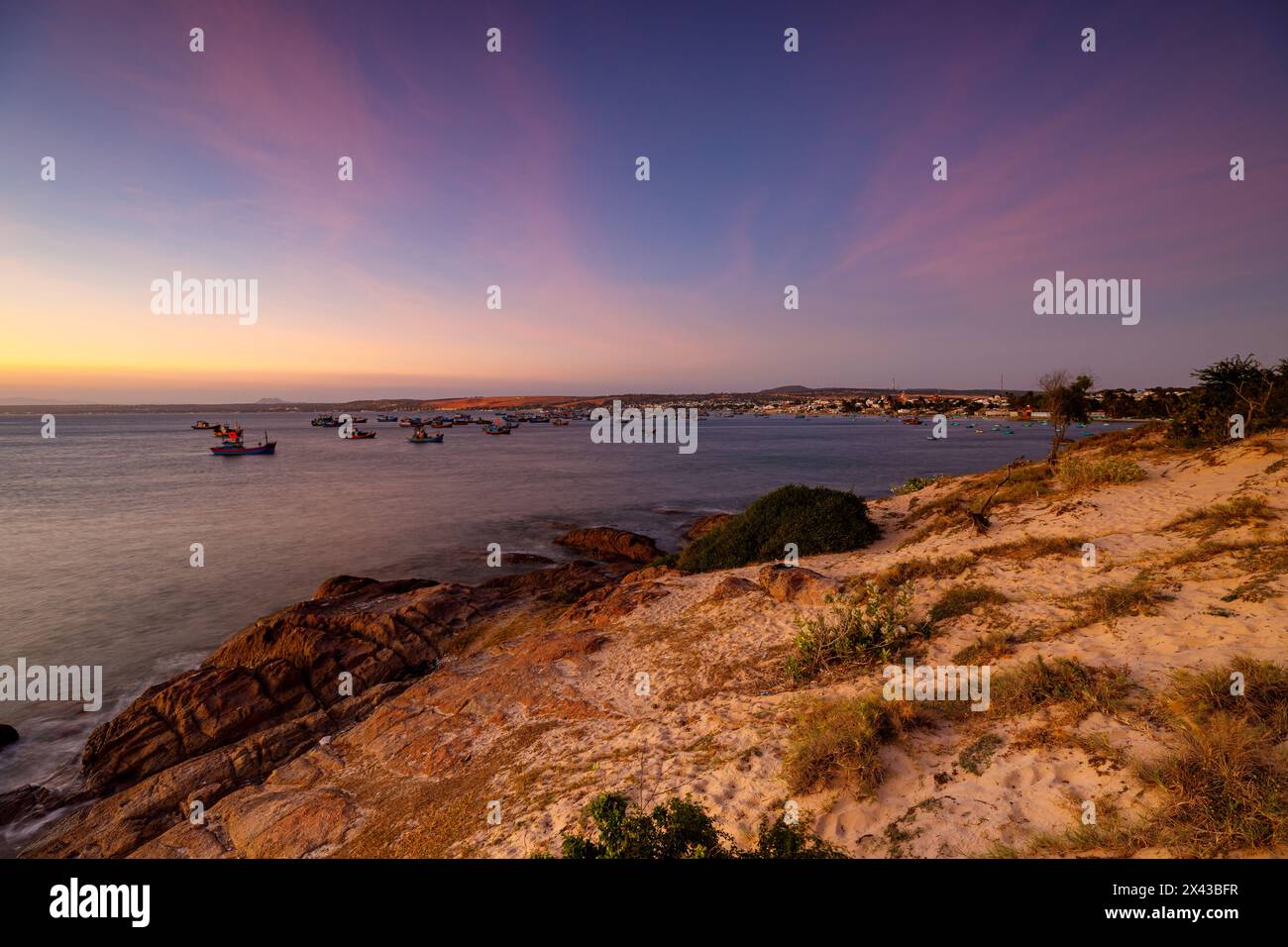 The harbor of Mui Ne in Vietnam with fisherboats at sunset Stock Photo ...