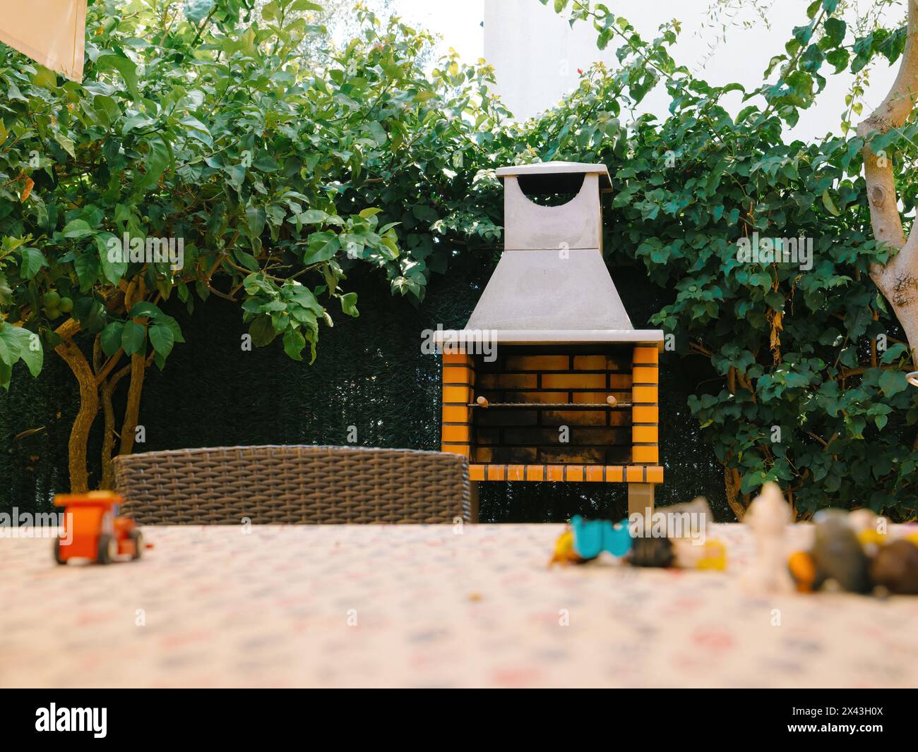 Family-friendly backyard scene with a barbecue setup and toys ...