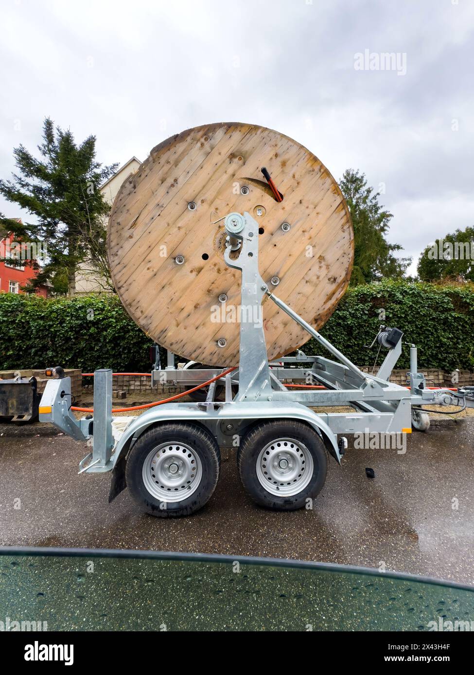 Giant wooden reel of optic fiber cable on a trailer at an installation ...