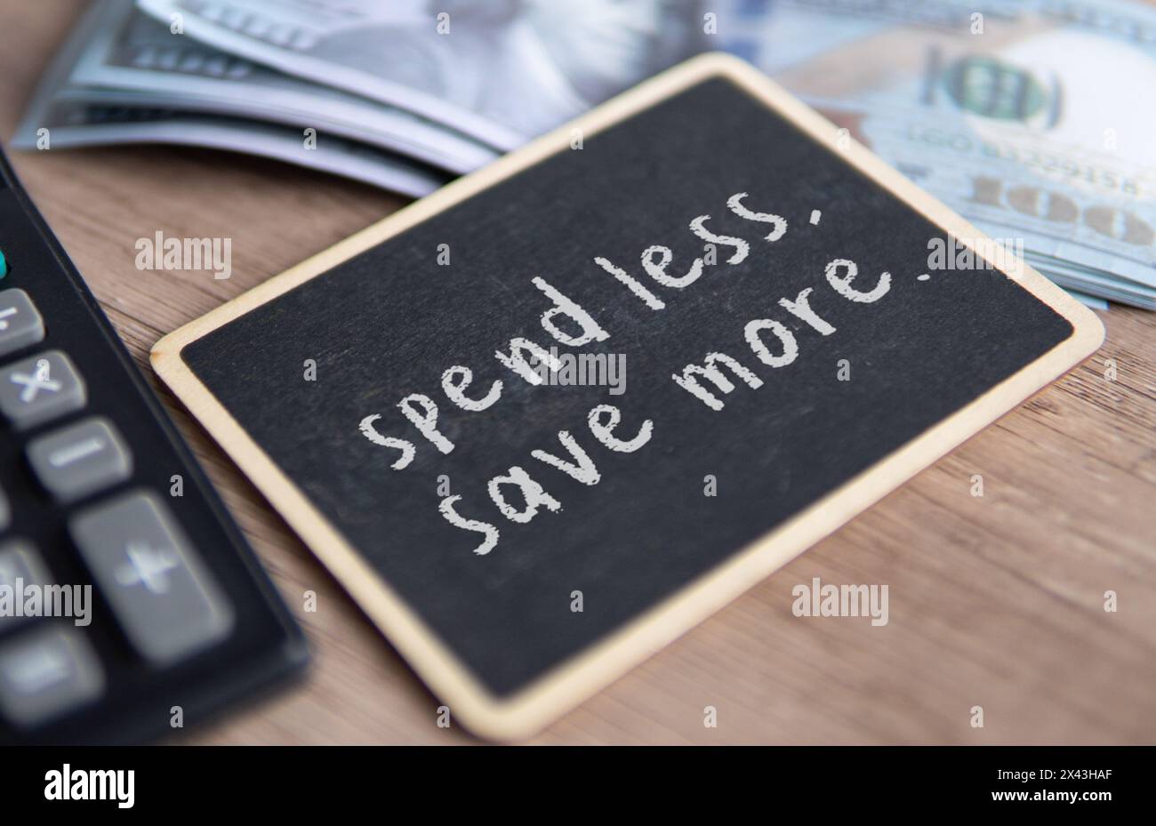 Top view image of chalkboard with text SPEND LESS, SAVE MORE surrounded ...