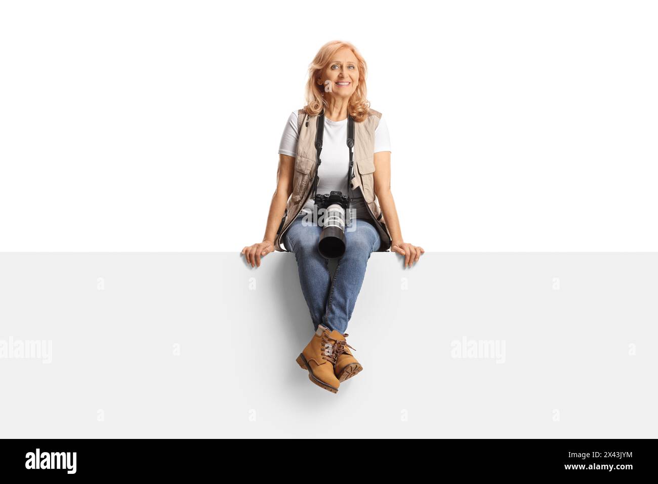 Female photo journalist sitting on a blank panel isolated on white ...