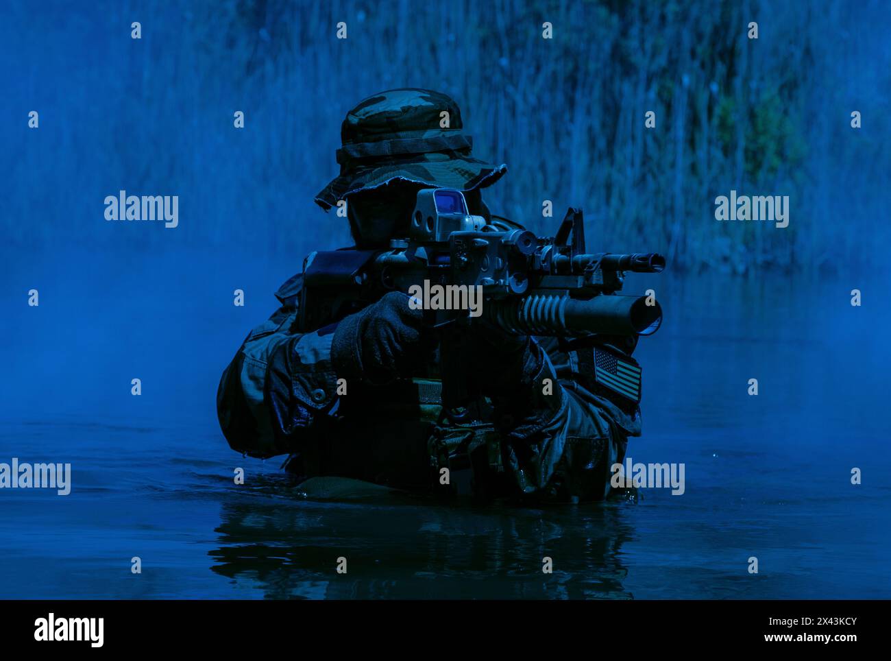 A bearded soldier performs a surveillance task in the water, walking ...