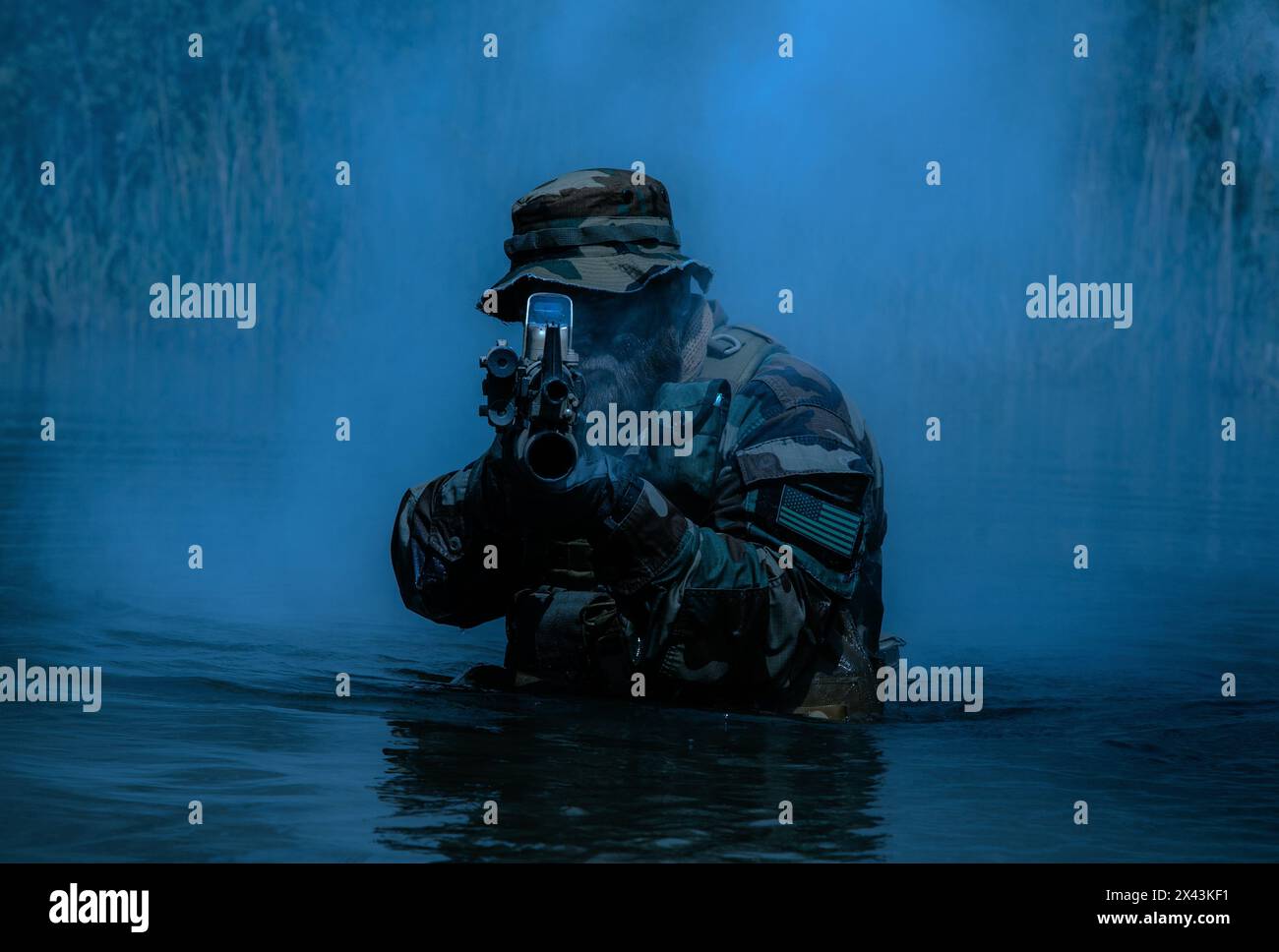 A bearded soldier performs a surveillance task in the water, walking ...