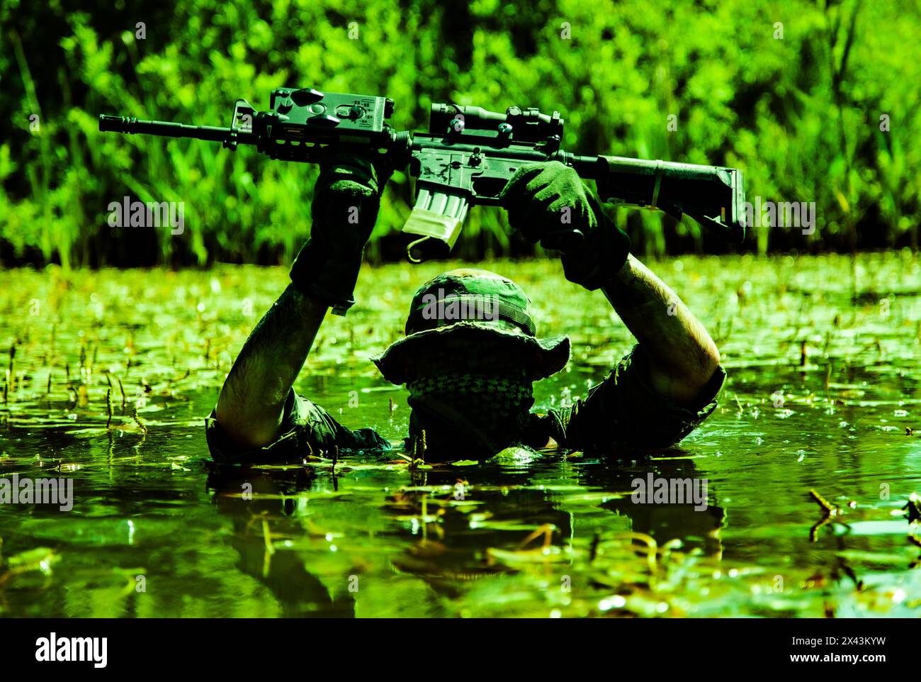 A soldier moves in the heart of a marsh, submerged in swampy waters ...