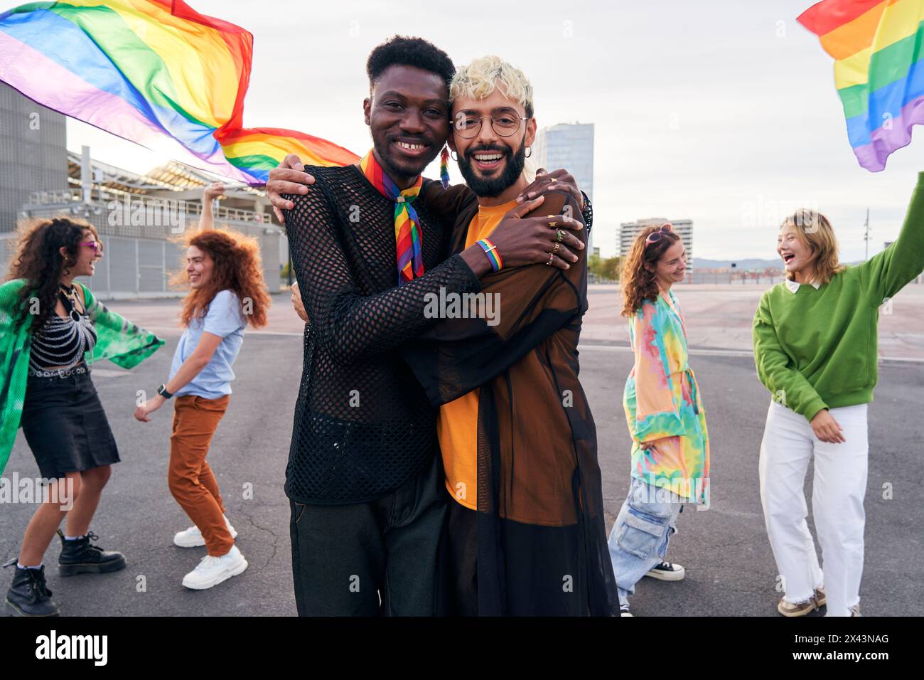 Two men at pride parade celebrating the LGBTQIA month hugging and ...