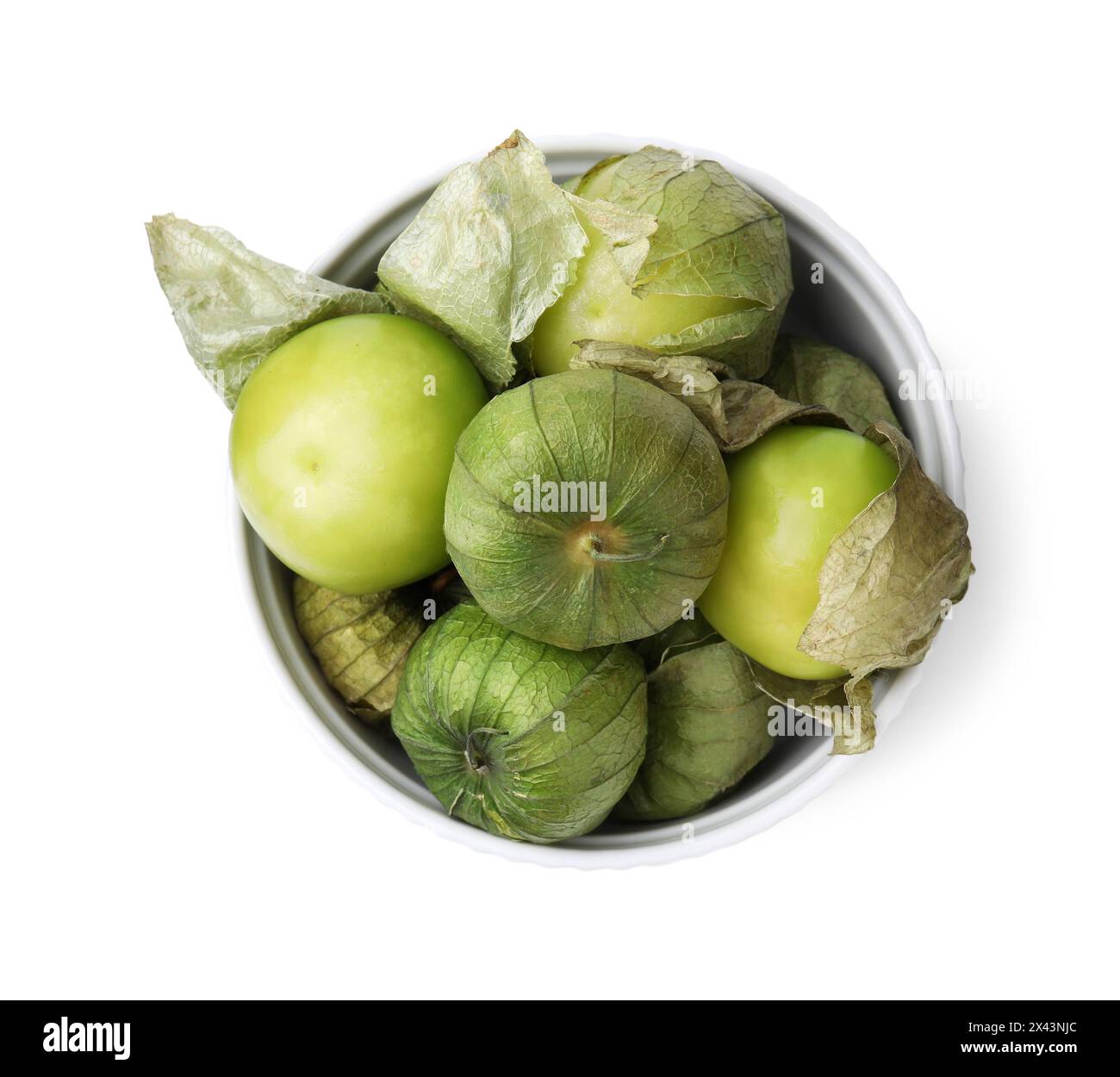 Bowl of fresh green tomatillos with husk isolated on white, top view ...