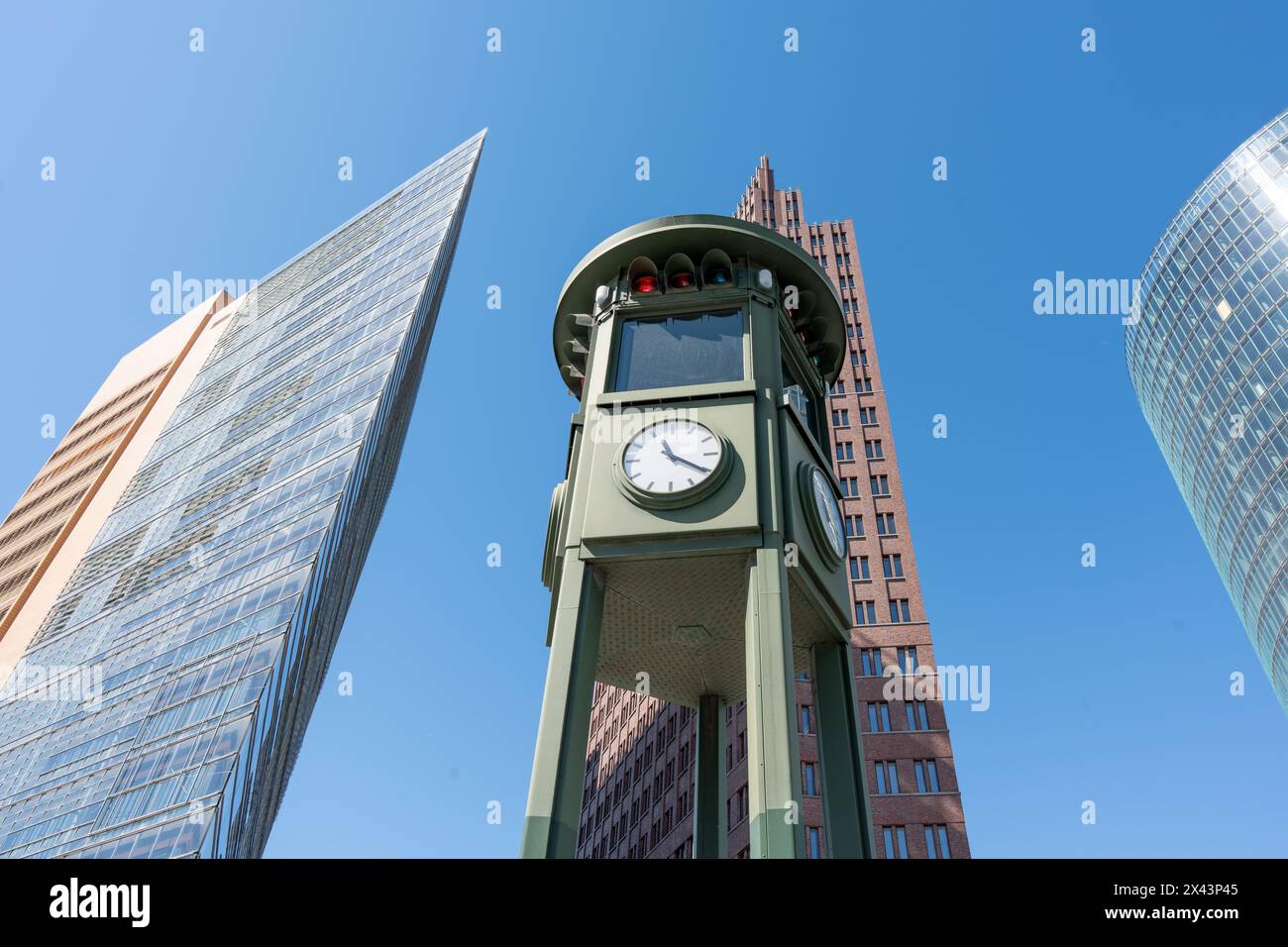 An old tower on which a clock and a traffic light are located against ...