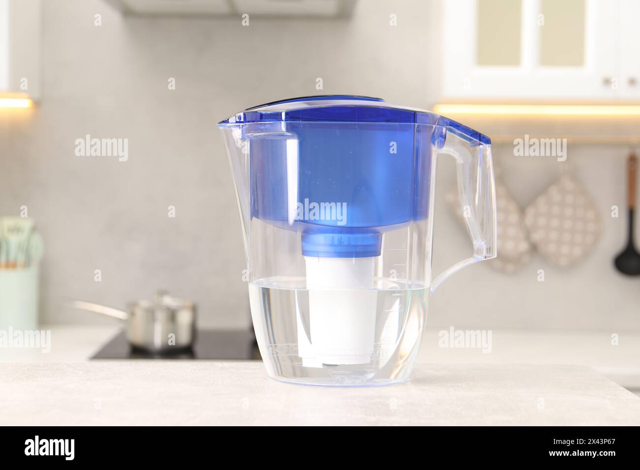 Water filter jug on light grey table in kitchen Stock Photo - Alamy