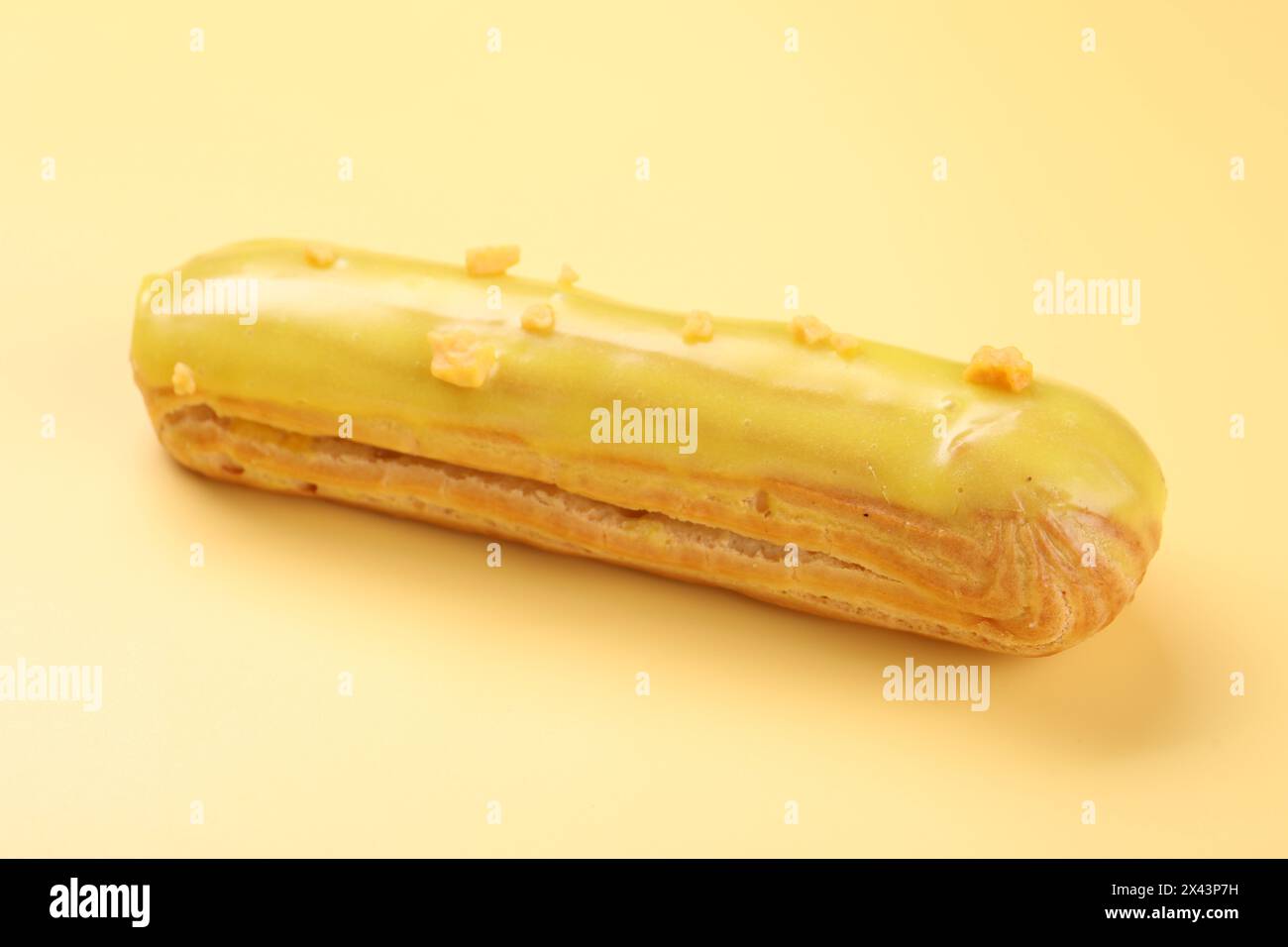 Delicious eclair covered with glaze on yellow background Stock Photo ...