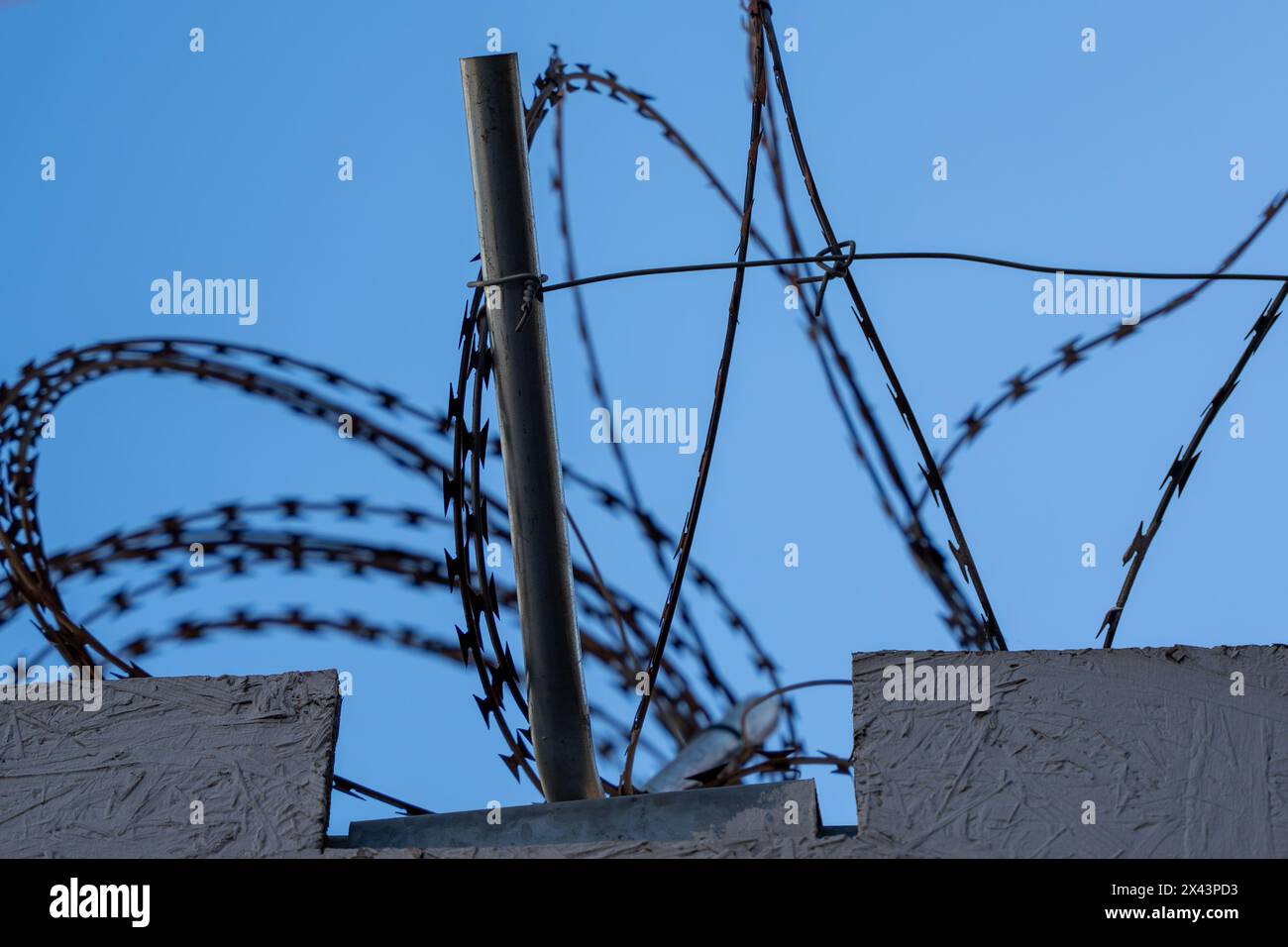 Barbed wire on top of a fence against a blue sky. Freedom concept Stock ...