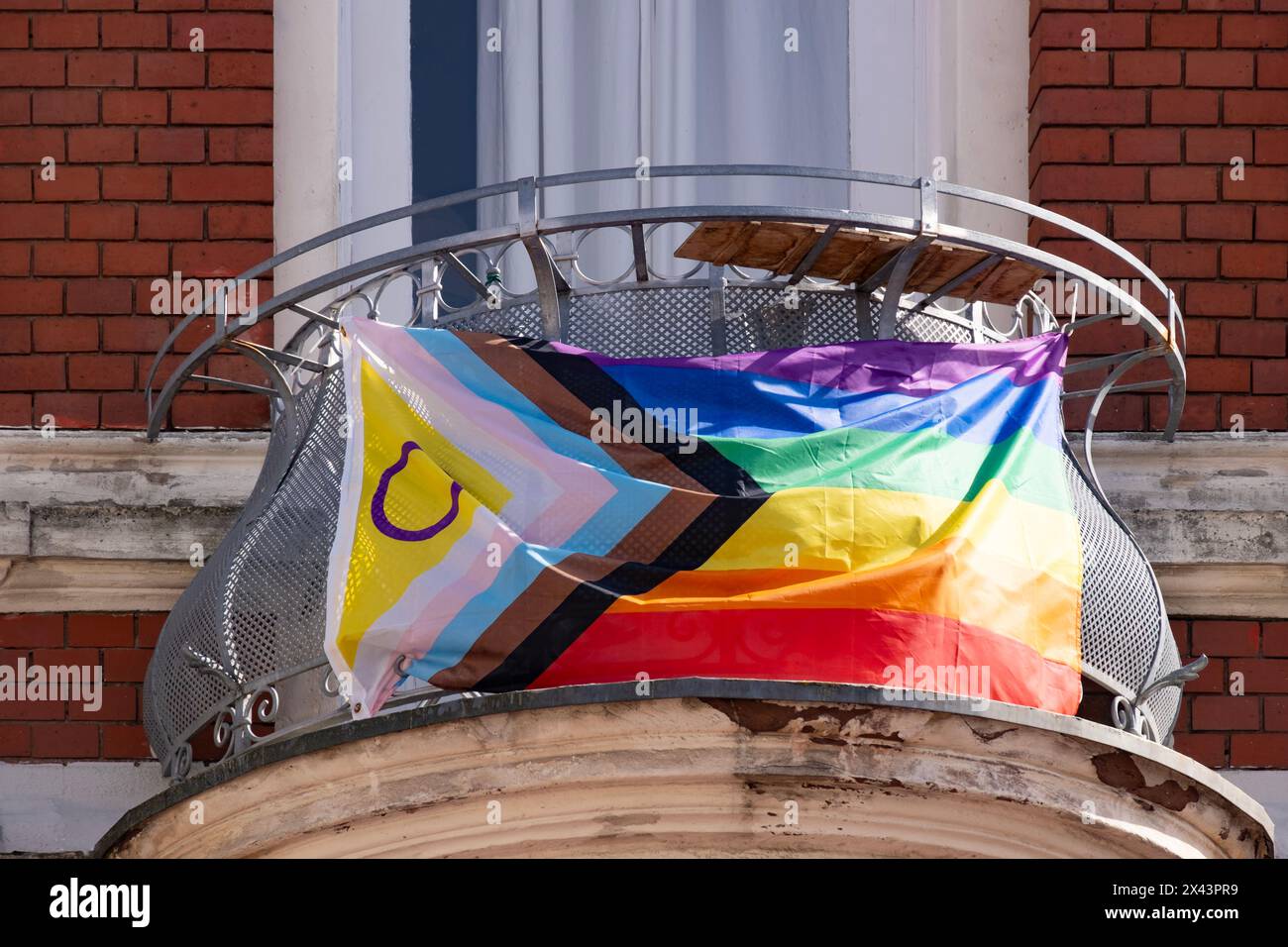 rainbow pride flag progress on balcony house, with black, brown, and ...