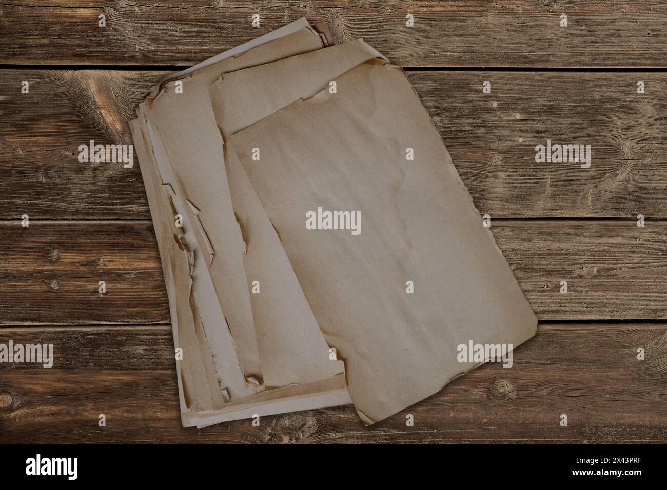 Closeup wooden desk with stack of old paper torn off edges for message ...