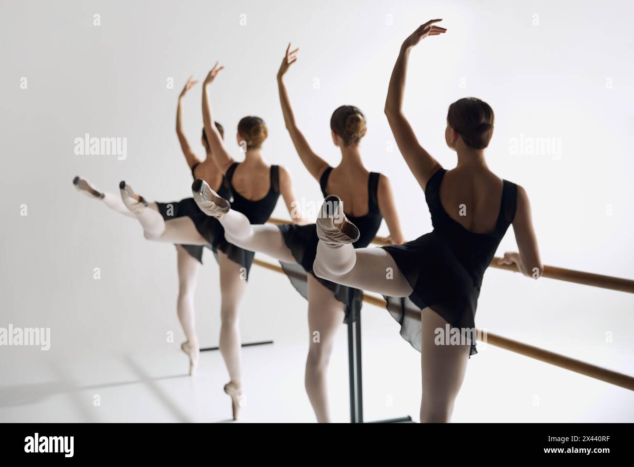 Teen girls, ballet dancers practicing at barre, focusing attention on ...