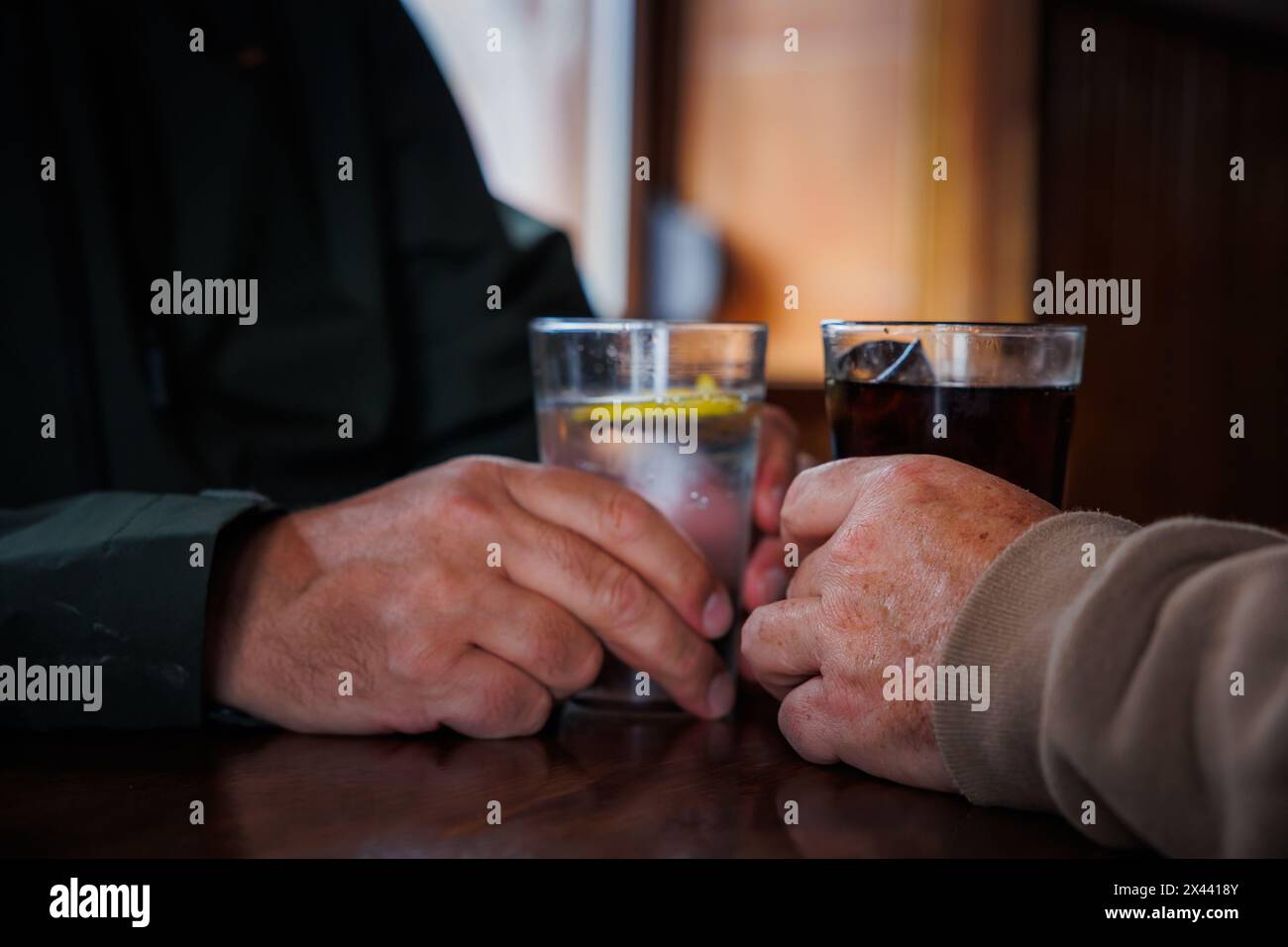 Two glasses of drink of two friends at the bar toasting on a wooden ...
