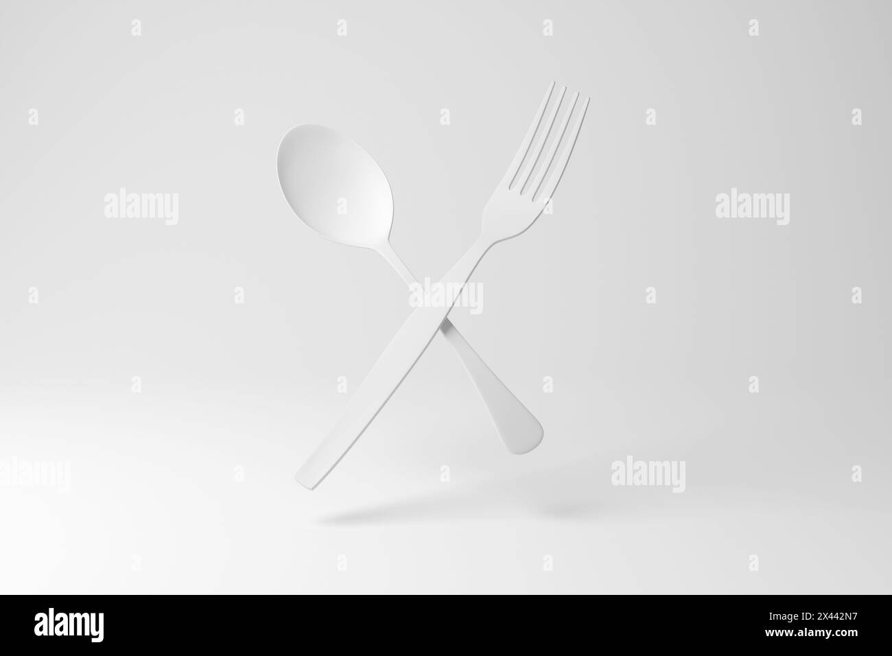 White fork and spoon floating in mid air on white background in ...