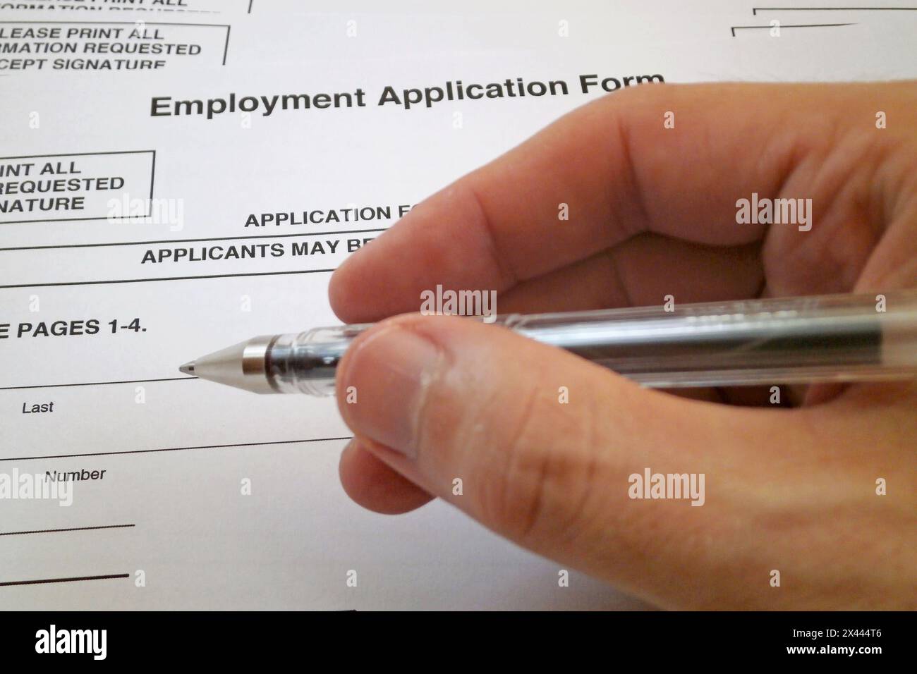Ballpoint pen hold in the hand of a man filling an Employment ...