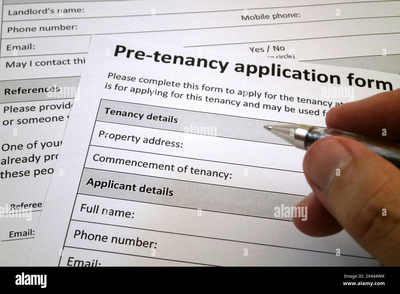 A ballpoint pen held by the fingers of a man filling a pre-tenancy ...