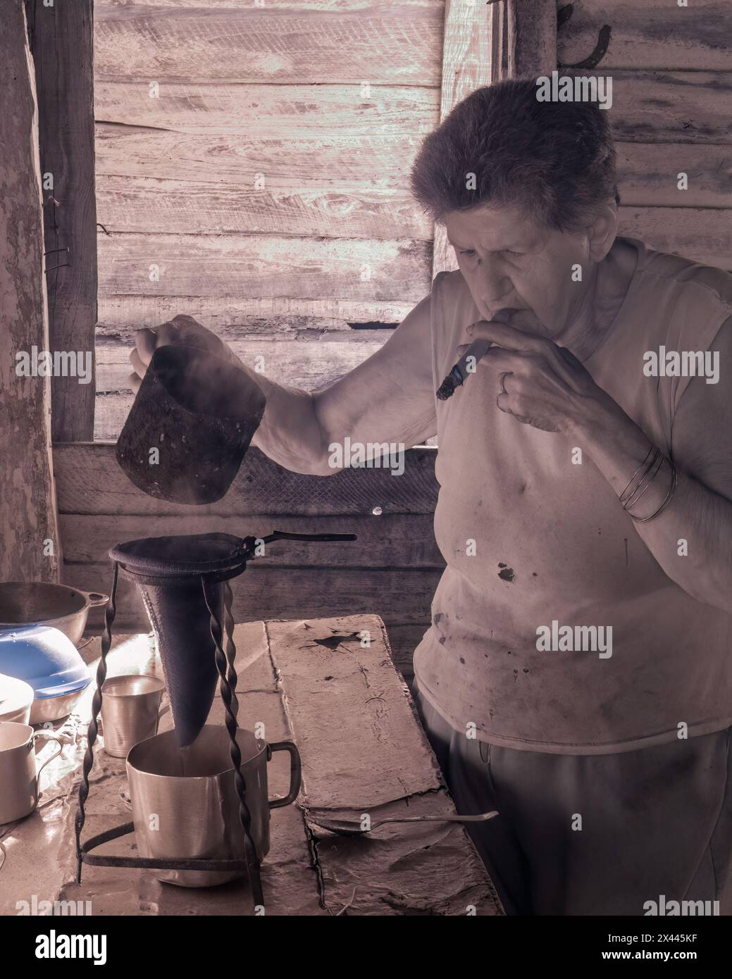 An infrared picture of a coffee farmers wife in the farmhouse smoking a ...