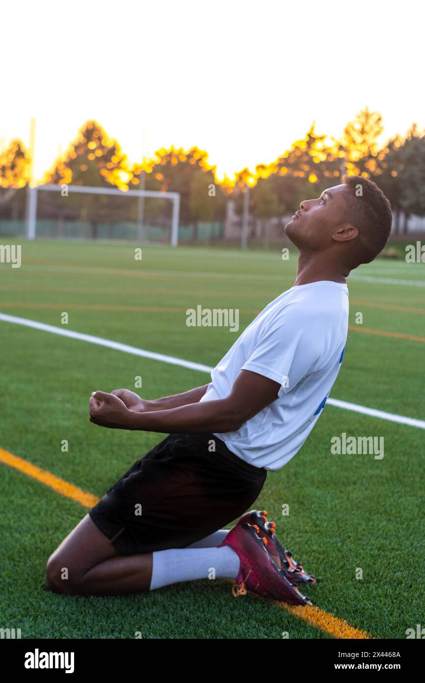 Soccer player on his knees celebrating a goal. Excited footballer man ...