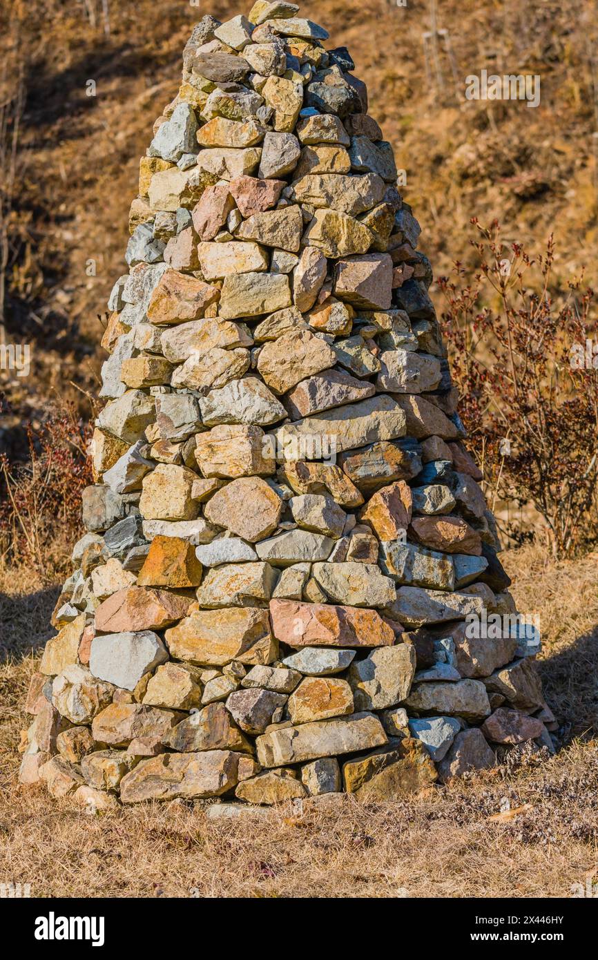 Closeup of pile of stones in the shape of an upside down cone in a ...