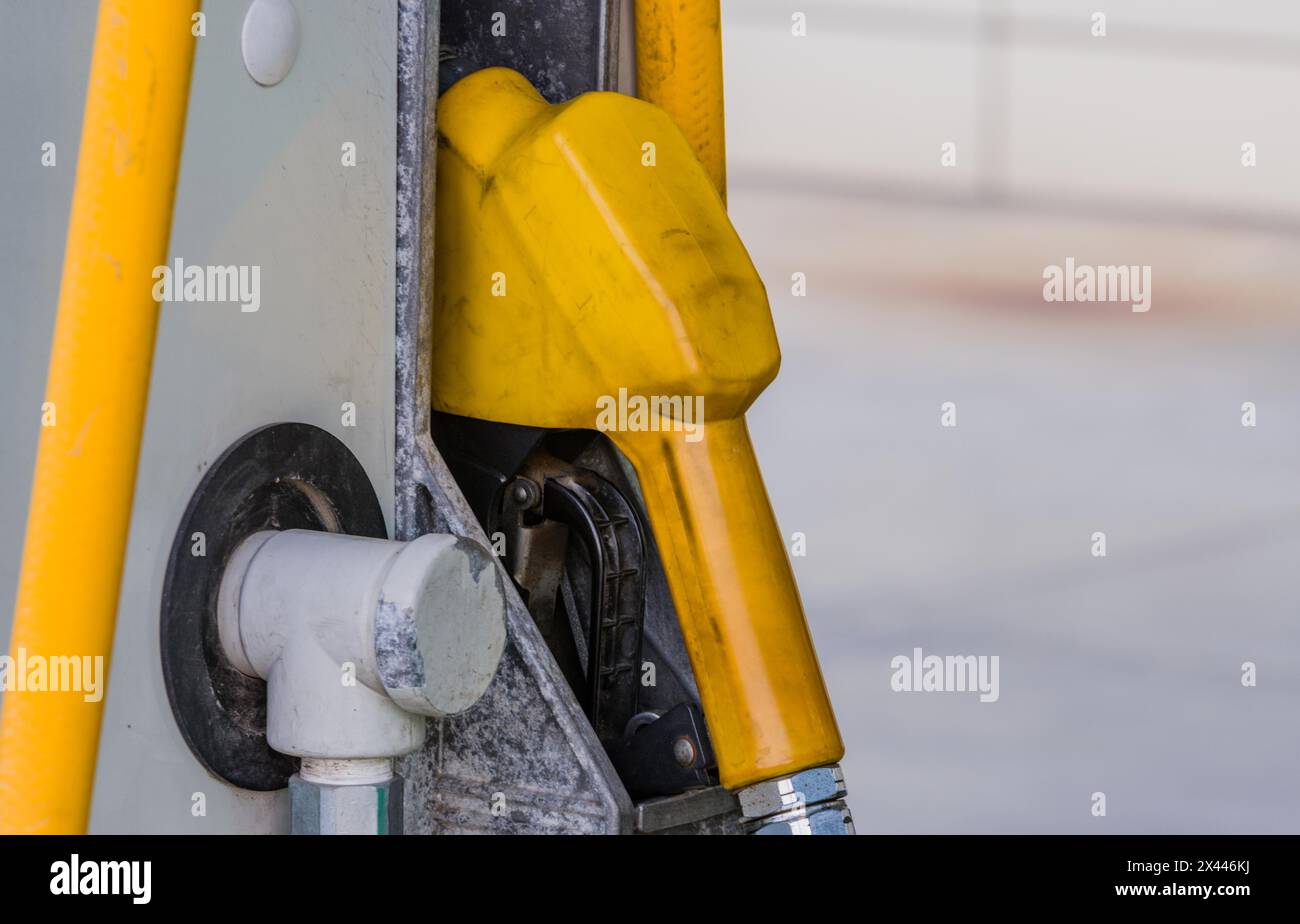 Closeup of gas pump handle with yellow rubberized cover inserted into ...