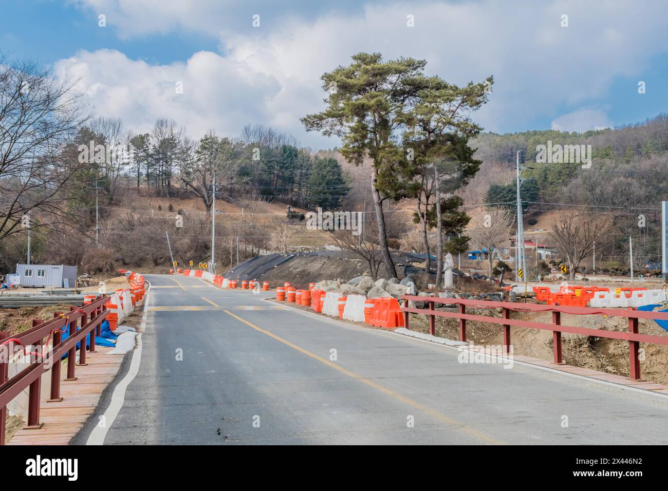 Traffic barriers on each side of two lane rural road construction site ...