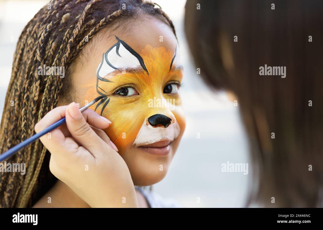 Little girl getting her face painted by face painting artist Stock ...