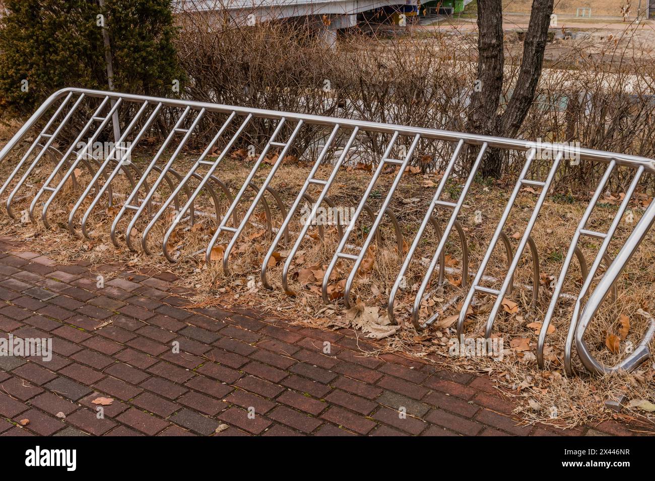 Empty stainless steel public bicycle rack next to red brick sidewalk in ...