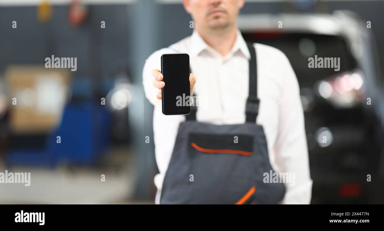 Male in working clothes showing gadget Stock Photo - Alamy