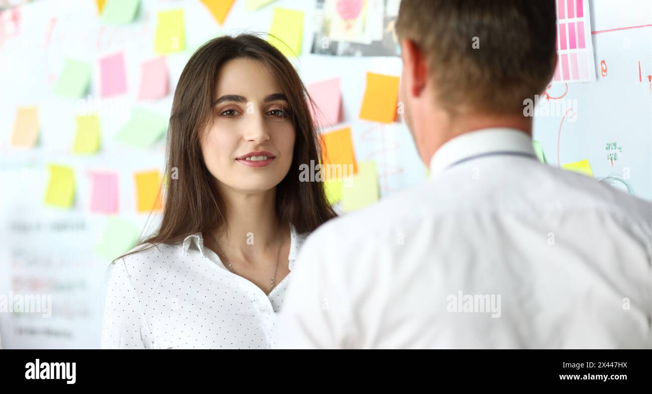Pretty female office worker consulting her male coworker Stock Photo ...