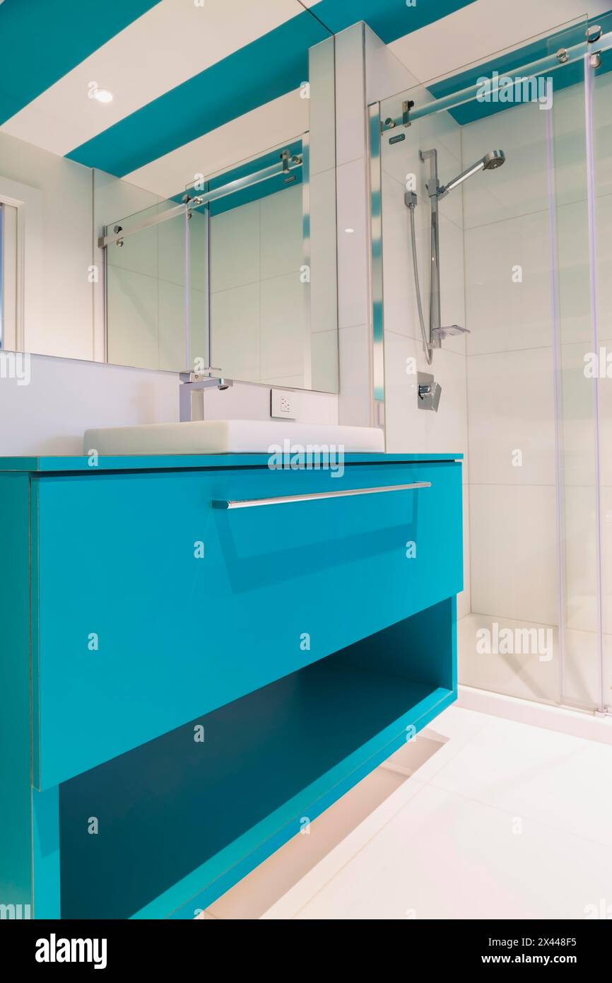 Blue laminated vanity with white rectangular shaped sink, clear glass ...