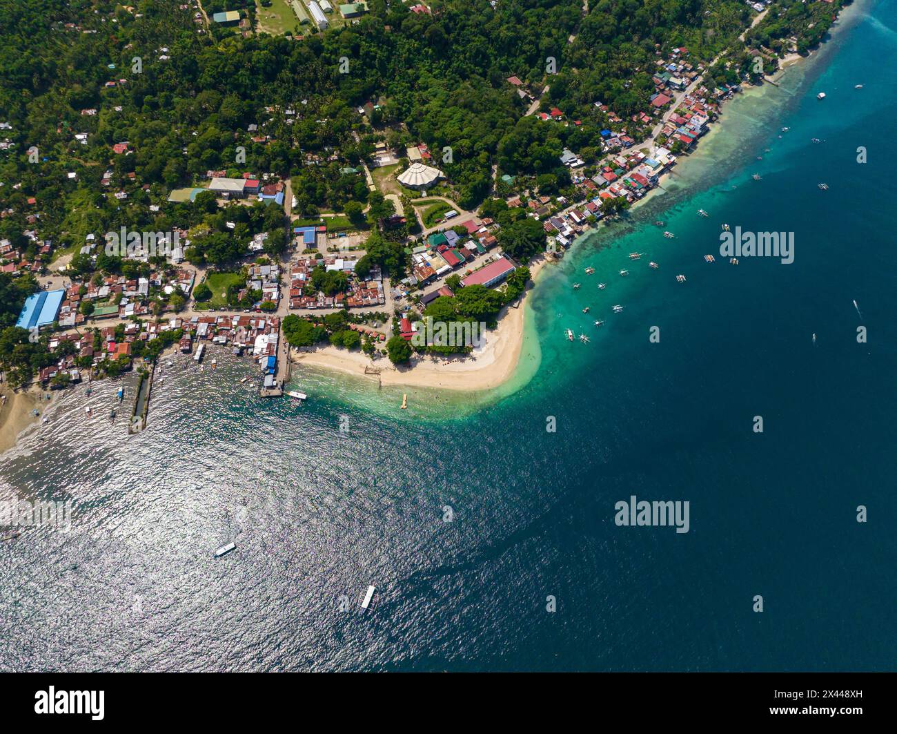 Coastline with houses and sandy white beach. Turquoise sea water with ...