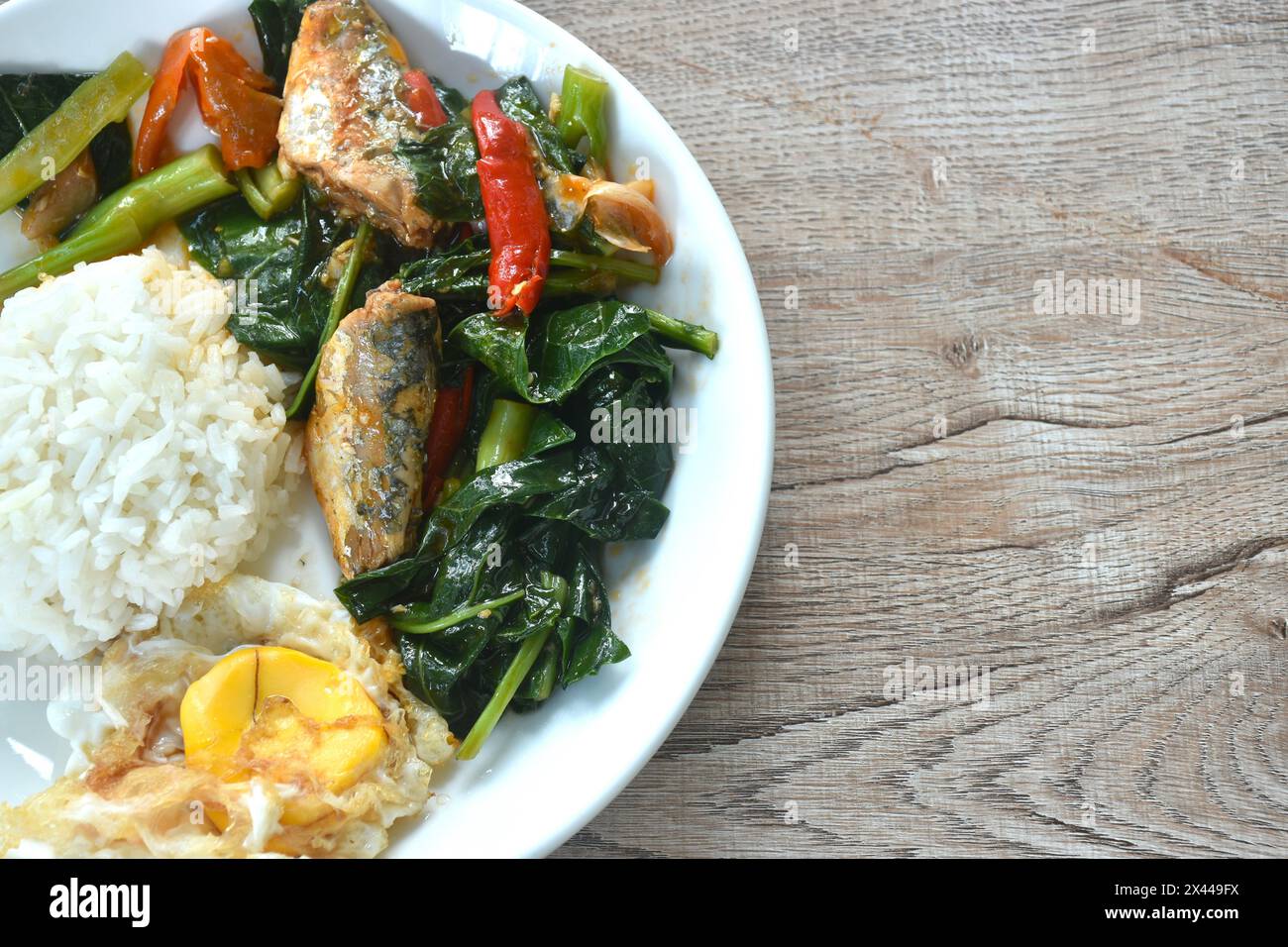 spicy stir fried Chinese kale with fish can in tomato sauce topping egg ...