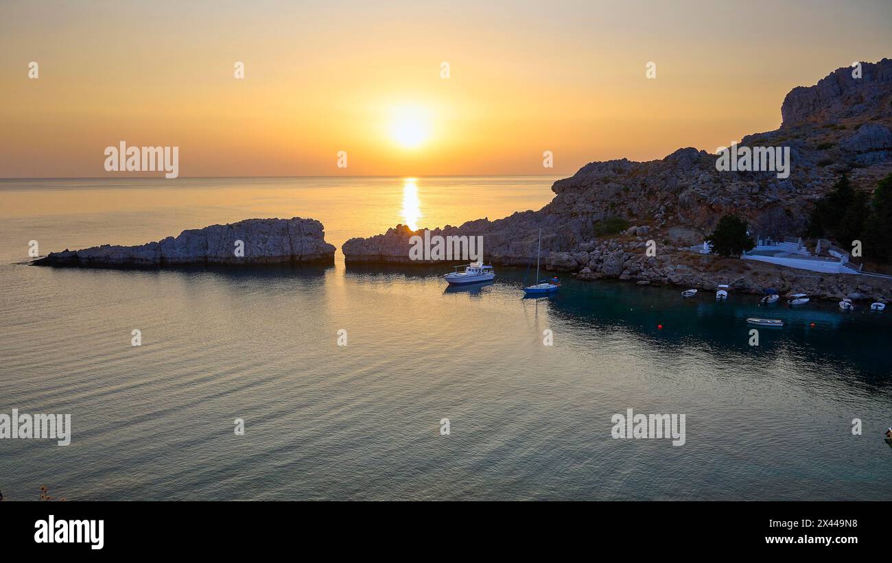 Golden glowing sunset over the calm sea next to rocky cliffs, Paulus ...