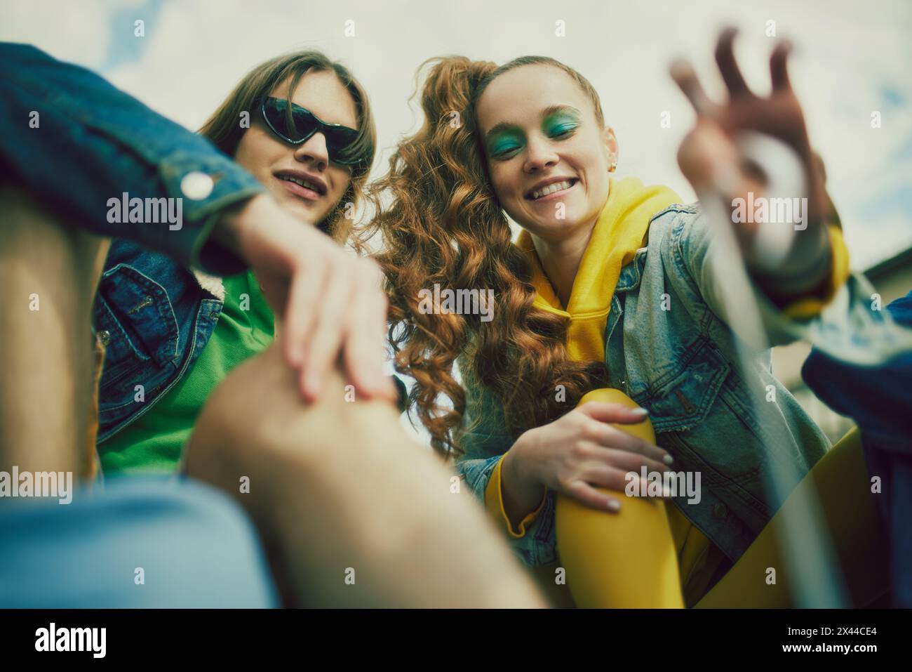Stylish young man and woman wearing colorful clothes mixing with denim ...