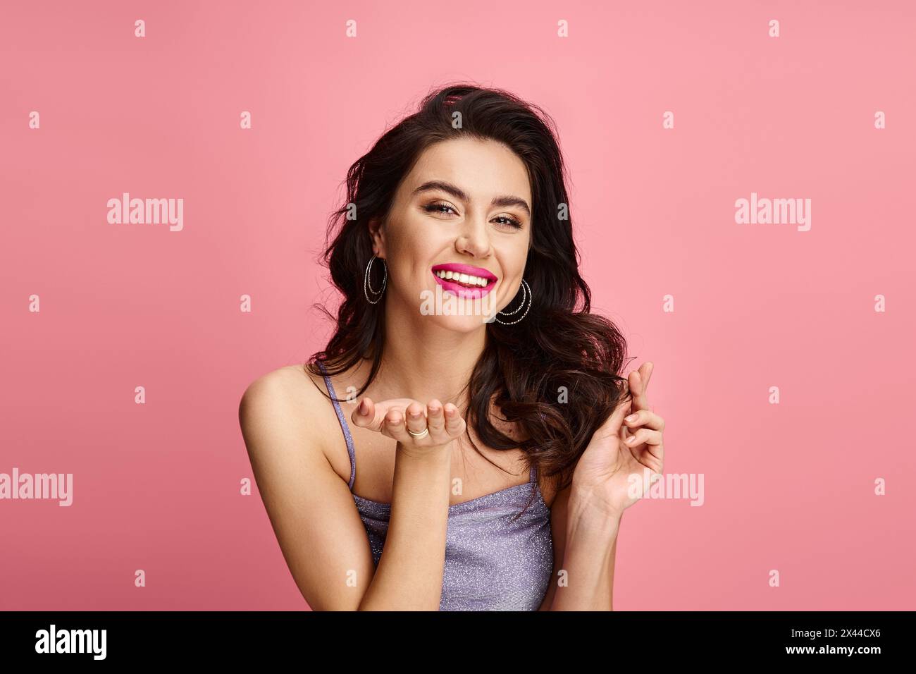 A natural beauty woman striking a pose against a vivid pink background ...