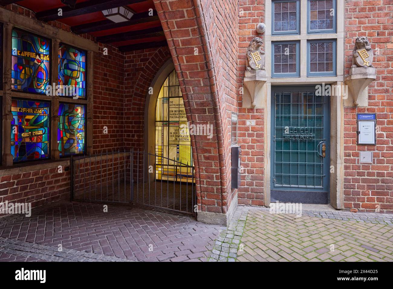 House entrance with old door, windows and two lions bearing a coat of ...
