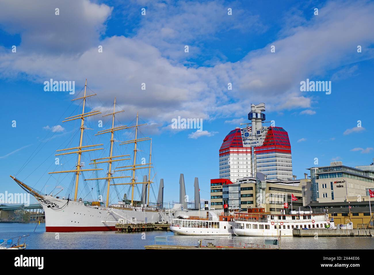 Sailing ship, small boats and a high-rise building in a harbour in ...
