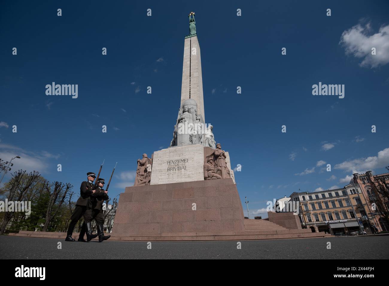 Two soldiers march in front of the Freedom Monument in Riga, Latvia ...