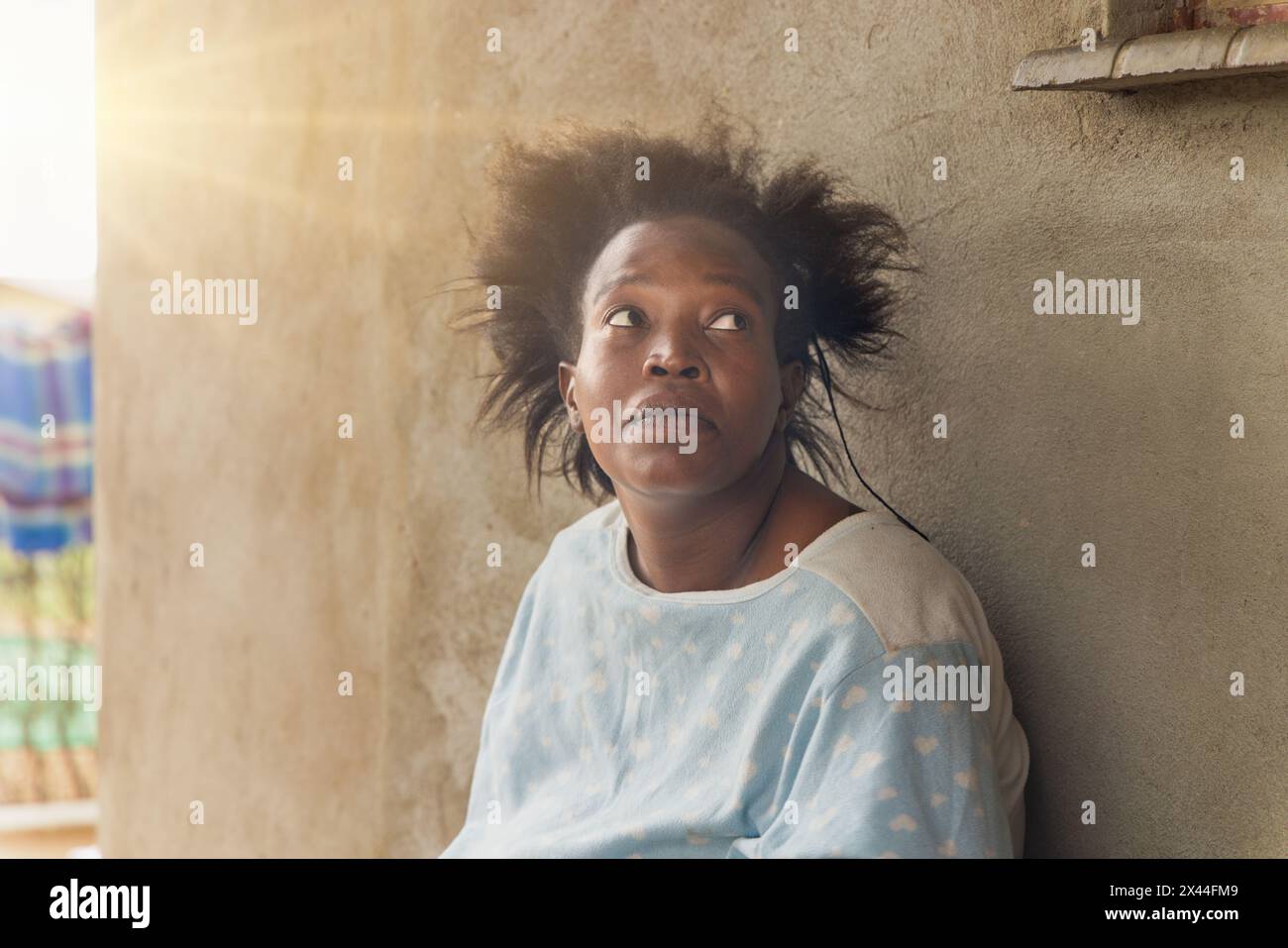 african village , lonely single woman in front of the house at sunset ...