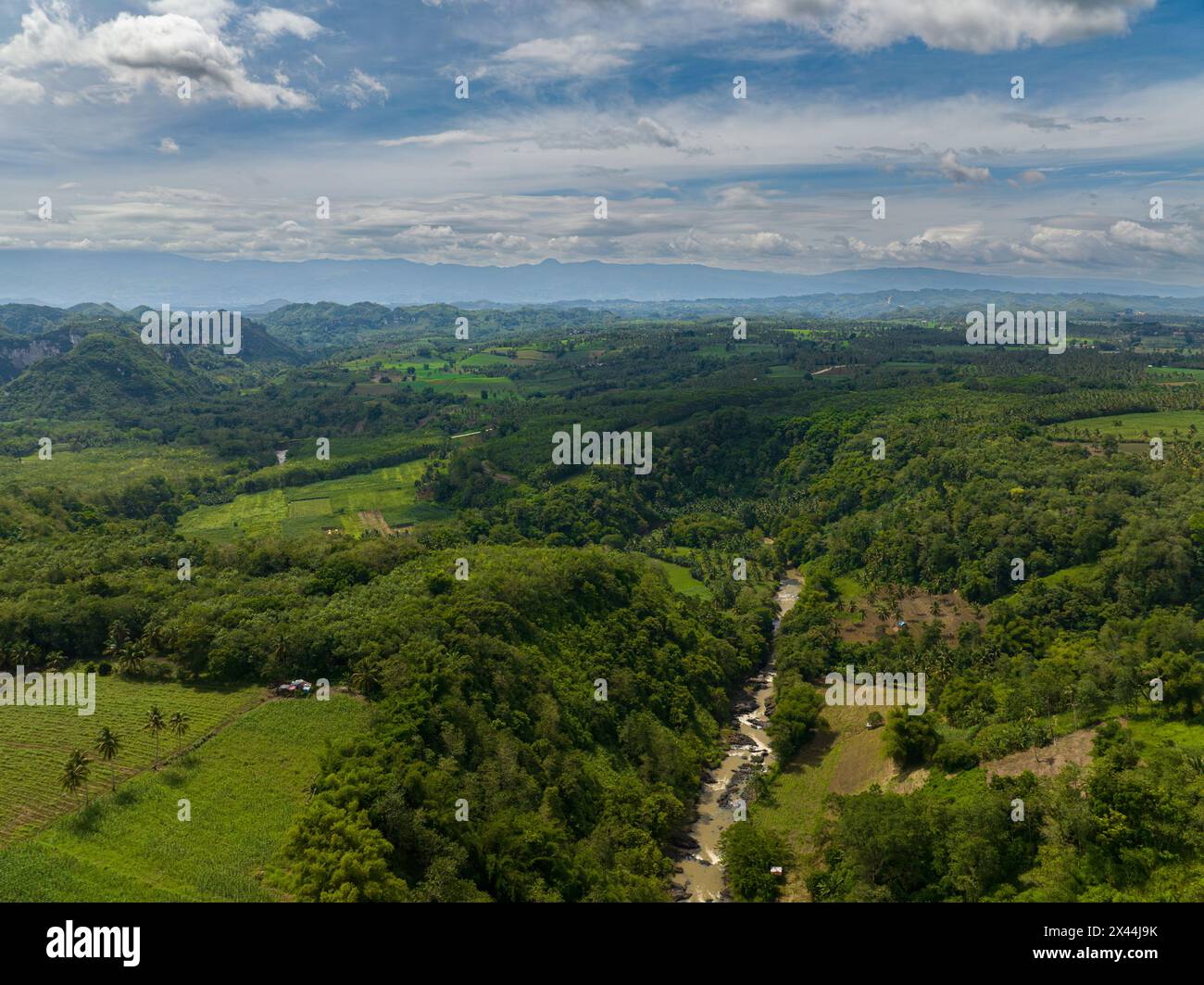 Tropical river over the mountain forest and farmland. Blue sky and ...