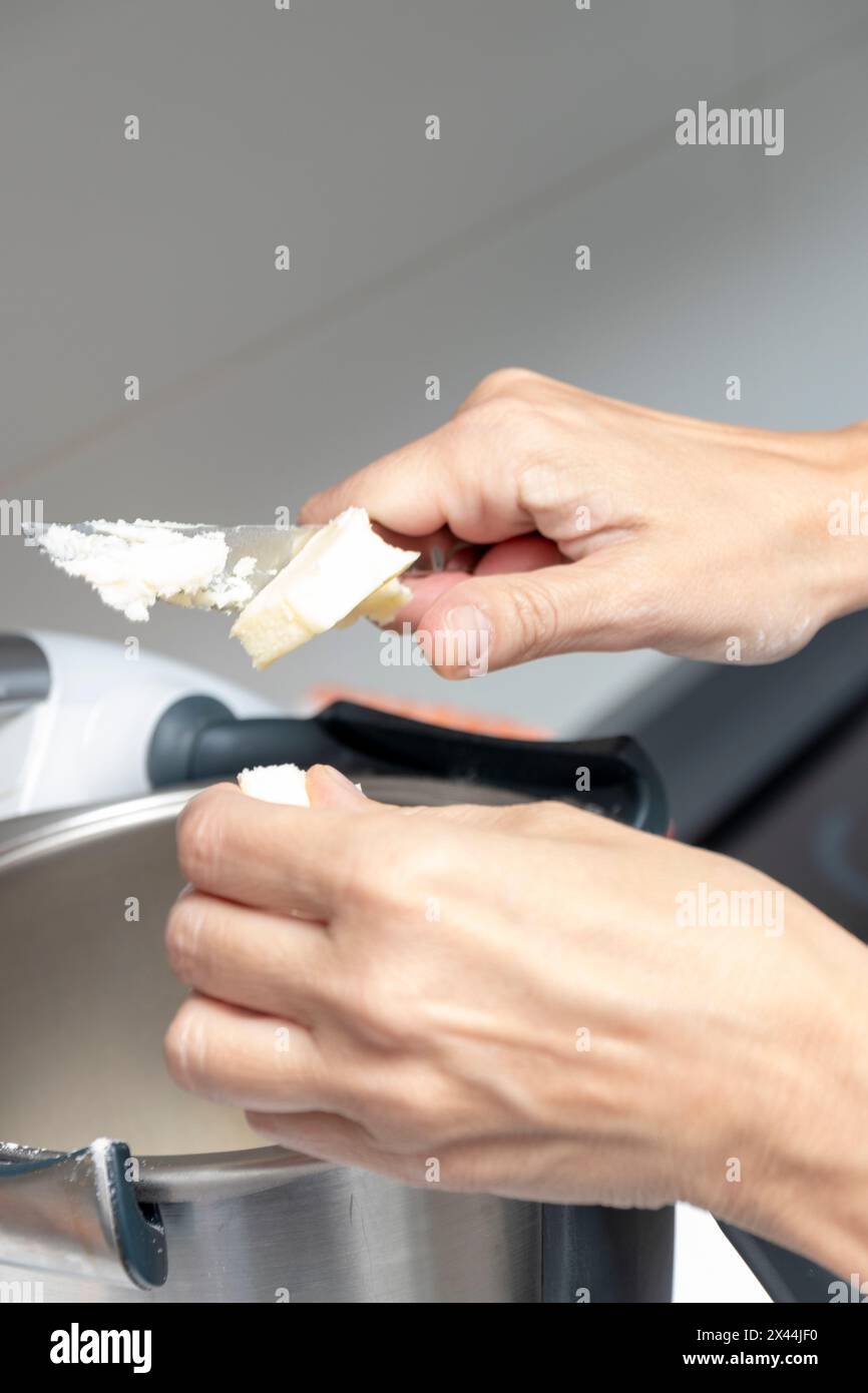 adding butter to a pot, beginning a cooking process, showcasing tactile ...