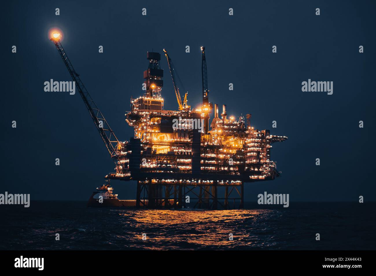 Offshore oil and gas jackup platform, during cargo operations with supply vessel in the sea at ...