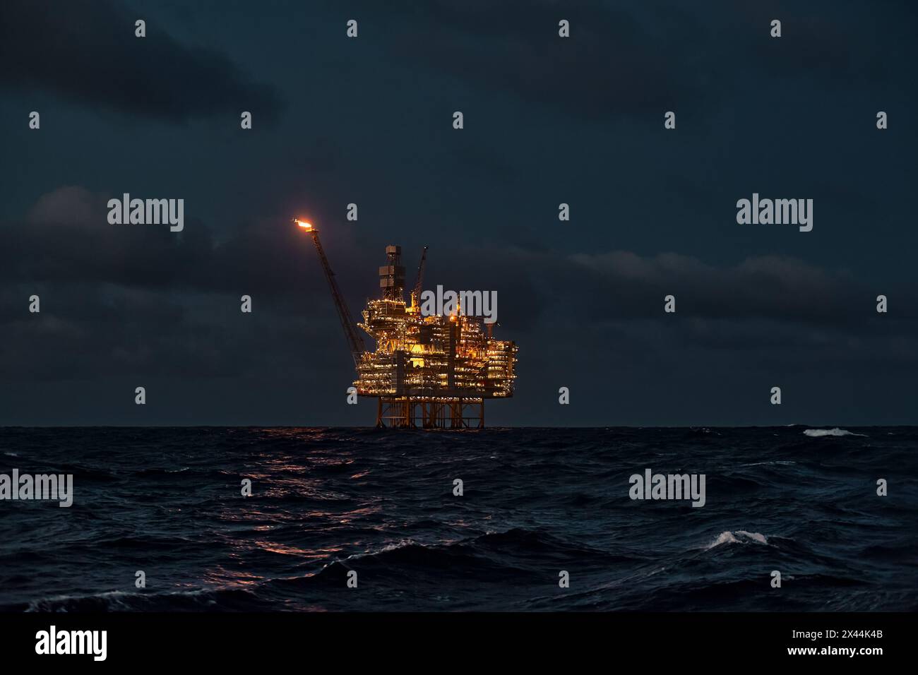 Panoramic view of offshore oil filed in the sea at night, with oil and ...