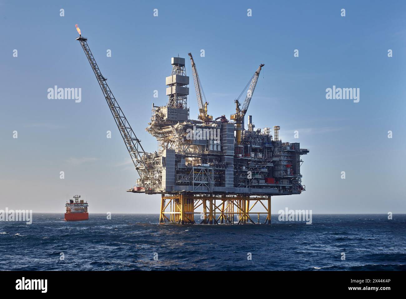 Jack up drilling rig and supply vessel in the sea with minimum colours ...