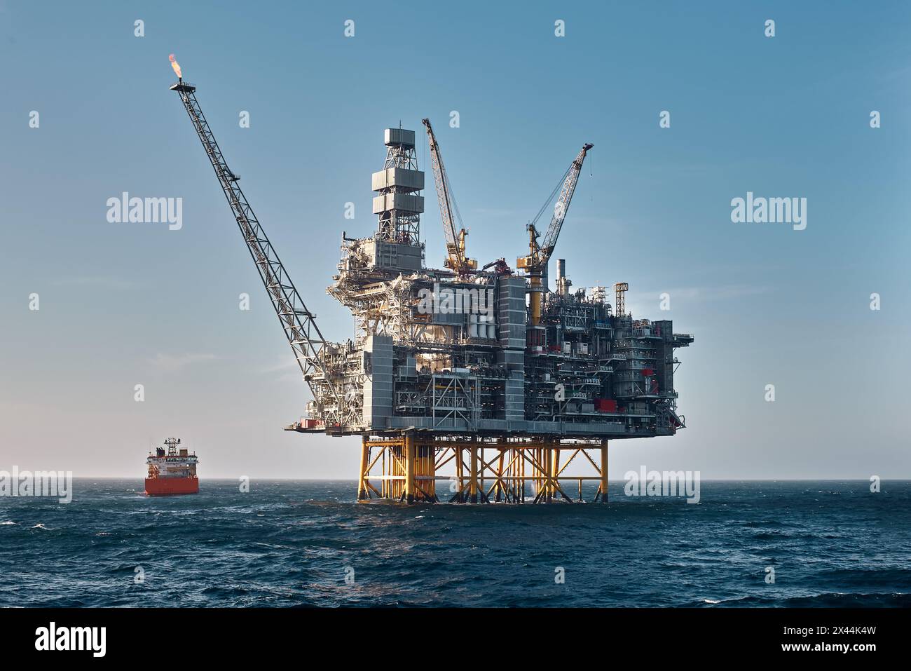 Jack up drilling rig and supply vessel in the sea with minimum colours ...