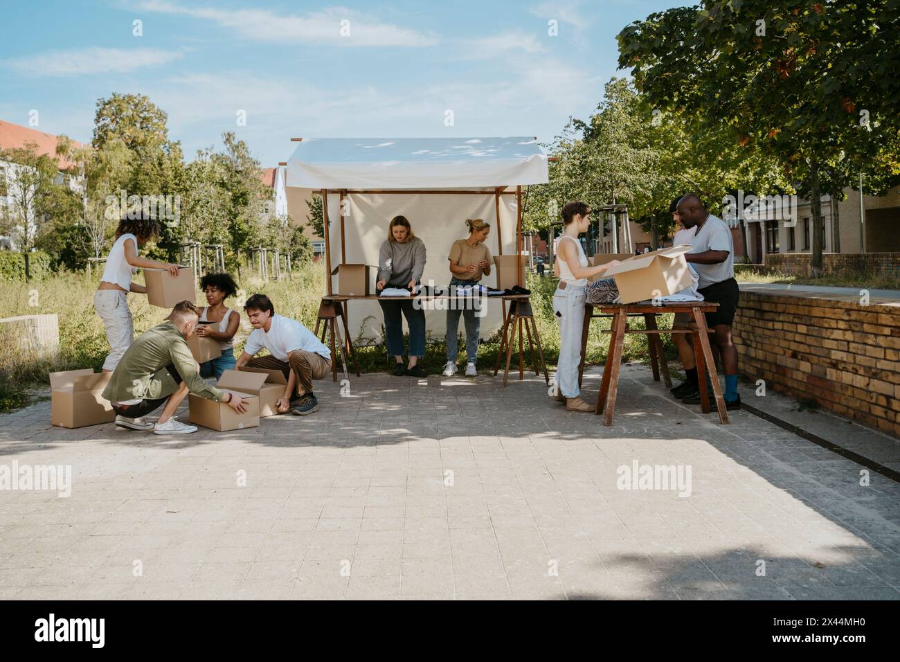 Multiracial group of volunteers helping each other while doing ...