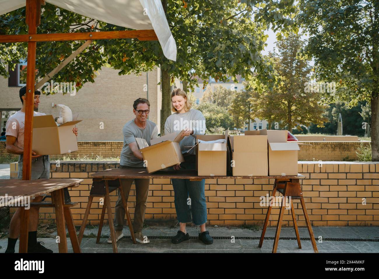 Group of multiracial volunteers arranging cardboard boxes on table ...