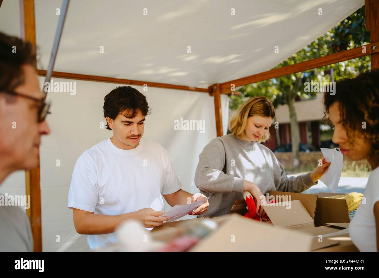 Group of multiracial volunteers labeling boxes during charity program ...